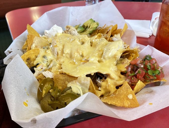 Nachos that defy gravity and good sense – a mountain of melty cheese, jalapeños, and happiness on crispy tortilla real estate.