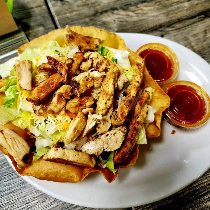 A taco salad that doesn't mess around – grilled chicken nestled in a crispy shell with all the fixings. Diet? What diet?