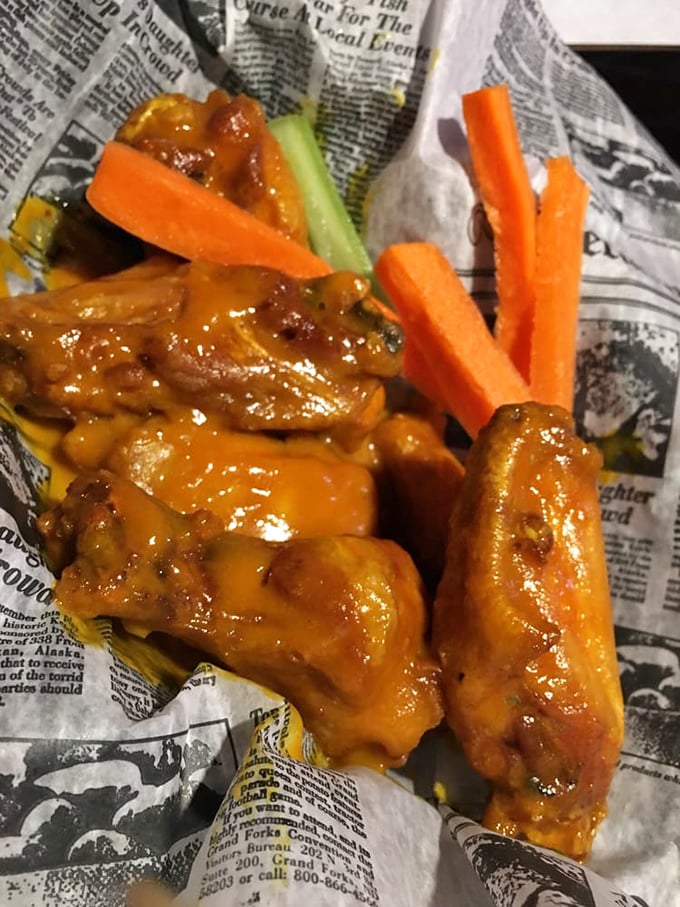 These wings aren't just sauced, they're dressed for success—glistening in tangy buffalo coating with crisp veggies standing by for relief.