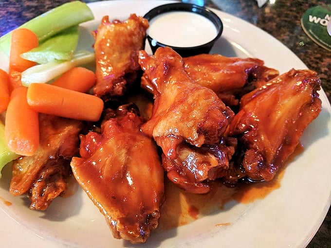These wings aren't just coated in sauce—they're having a full-on flavor affair with it. The celery and carrots are just there to witness.