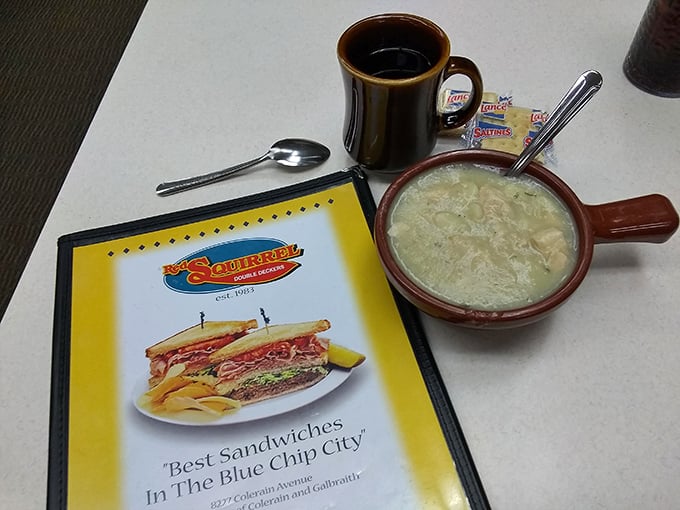 A hearty bowl of chicken and dumplings alongside the menu promising "Best Sandwiches in the Blue Chip City"—comfort in both liquid and solid form.