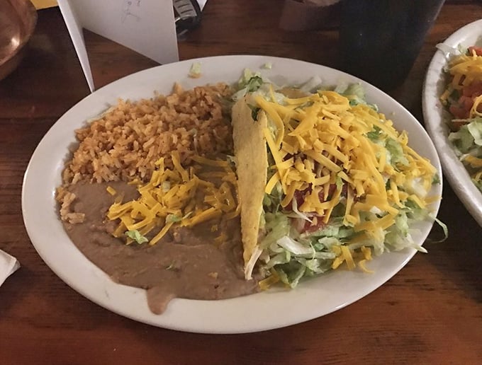 A perfect harmony of textures: crispy taco shell, fluffy rice, velvety beans. This isn't just lunch—it's a symphony orchestra conducted by someone's abuela.