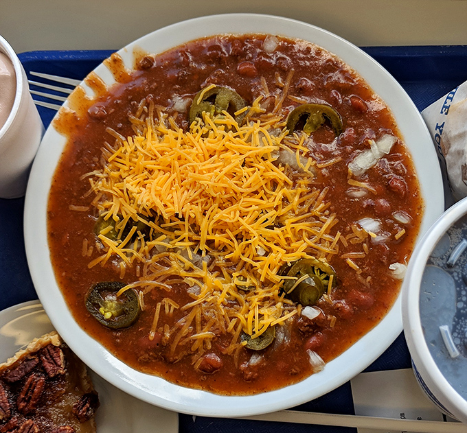 Behold, the famous chili in all its glory—a spiced symphony topped with a snowfall of cheddar and jalapeño islands.
