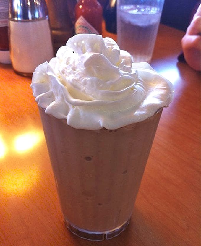 A milkshake with whipped cream stacked so high it needs its own zip code – dessert masquerading as a beverage.