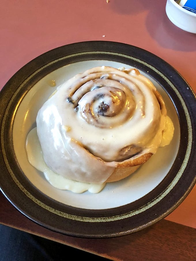 This cinnamon roll isn't just breakfast—it's an event. That glaze cascading down the sides is performing a sweet symphony for your taste buds.