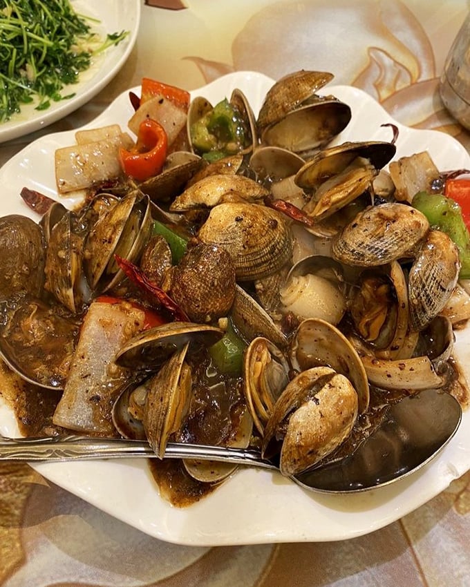 These clams in black bean sauce aren't just swimming—they're performing synchronized flavor Olympics with bell peppers and aromatics.