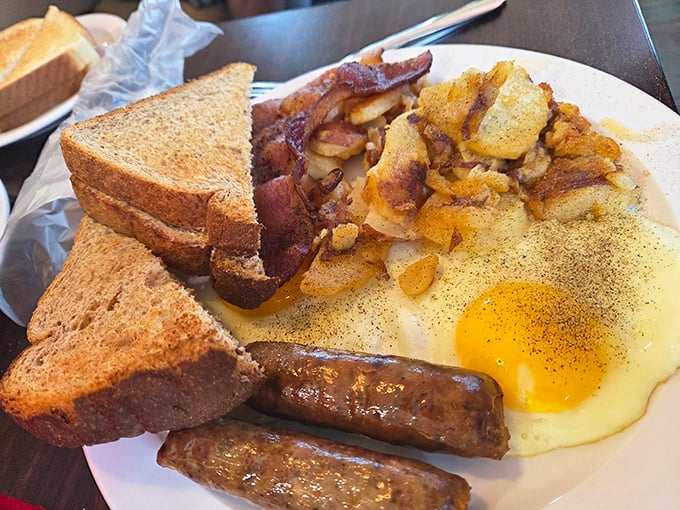 The breakfast plate that launched a thousand road trips – eggs, bacon, toast, and hash browns arranged like the four elements of morning perfection.