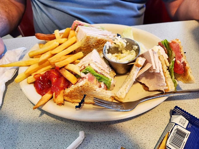 The club sandwich arrives like architectural perfection – layers of goodness that would make Frank Lloyd Wright jealous.