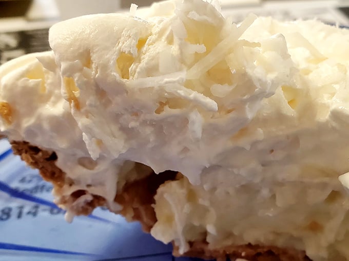 This coconut cream pie doesn't just have height—it has ambition. A skyscraper of whipped cream and coconut that demands to be photographed before demolished.