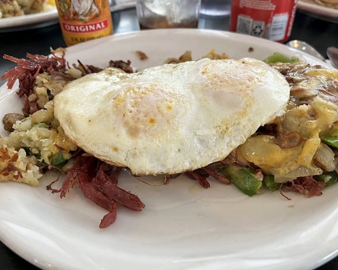 This isn't just a hash – it's a beautiful chaos of potatoes, corned beef, and vegetables, crowned with an egg cooked just right.