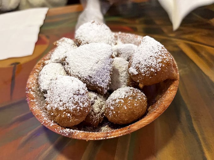 Golden-brown beignet-like treasures dusted with powdered sugar – dessert masquerading as an appetizer, and nobody's complaining.