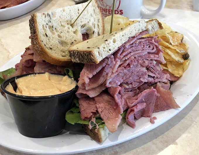 A sandwich that requires both hands and a strategy—layers of pink corned beef practically waving hello between slices of rye.