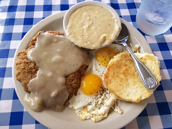 Country fried steak swimming in gravy with eggs and grits—the breakfast equivalent of hitting the Southern comfort jackpot.