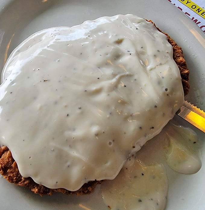 Country fried steak swimming in creamy gravy—proof that sometimes the most delicious things aren't the most photogenic. Pure comfort.