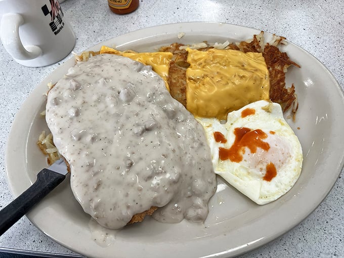 Country fried steak swimming in peppery gravy—proof that breakfast can double as armor against whatever the day might throw at you.