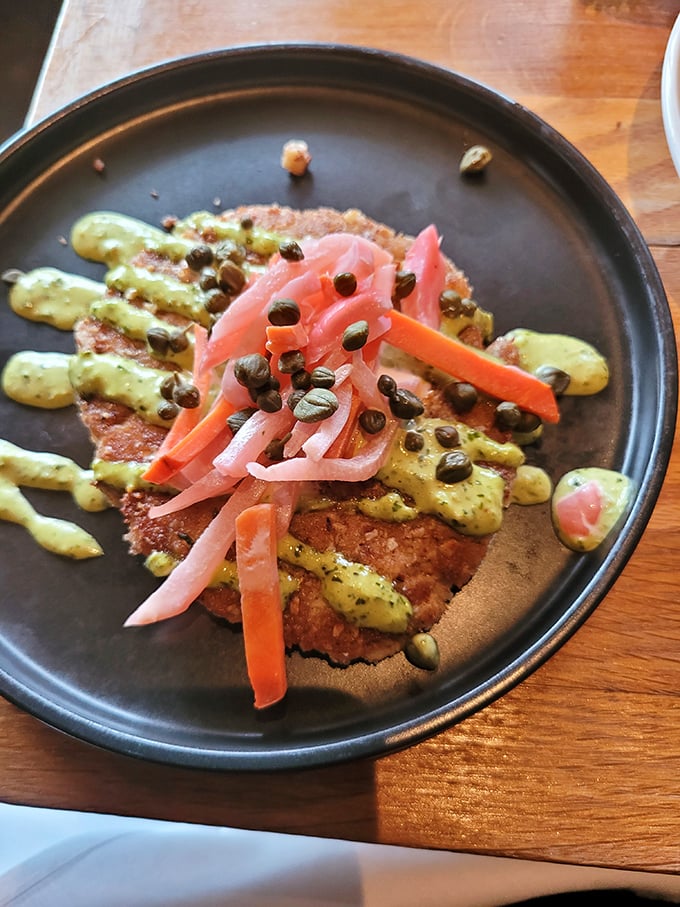 A crab cake that doesn't hide behind fillers—just pure, unadulterated seafood goodness with pickled vegetables for contrast.