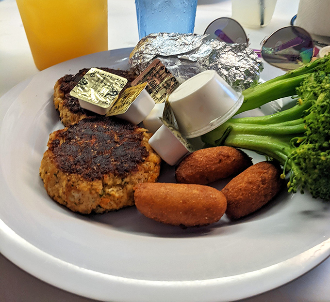 The crab cake that launched a thousand road trips – perfectly seared, minimal filler, and paired with hush puppies that could make a Southerner weep with joy.