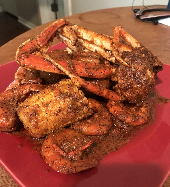 A mountain of seasoned crab legs and corn that says, "Cancel your next appointment – you'll be here a while."