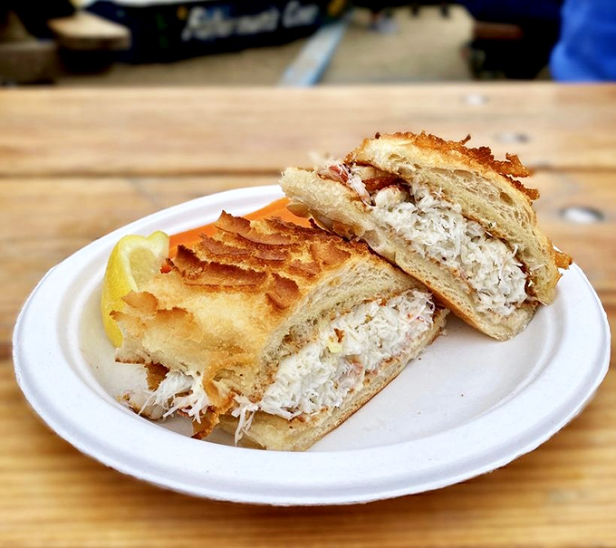 Behold the crab sandwich in its natural habitat—simple white bread letting chunks of sweet Dungeness crab take center stage, like the supporting actor who knows the star needs room.