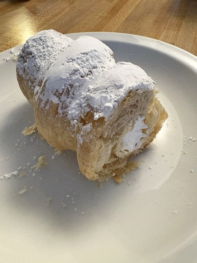 This cream horn doesn't just whisper sweetness—it announces it with a powdered sugar fanfare that makes napkins necessary but entirely worth it.