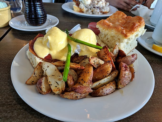 Eggs Benedict elevated to an art form—where hollandaise cascades like a yellow waterfall over perfectly poached eggs and those country potatoes play a delicious supporting role.