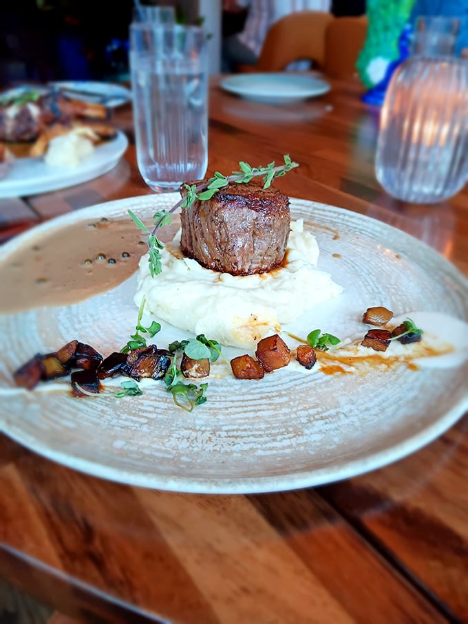 The filet mignon sits majestically on whipped potatoes like a tiny beef throne surrounded by mushroom courtiers.