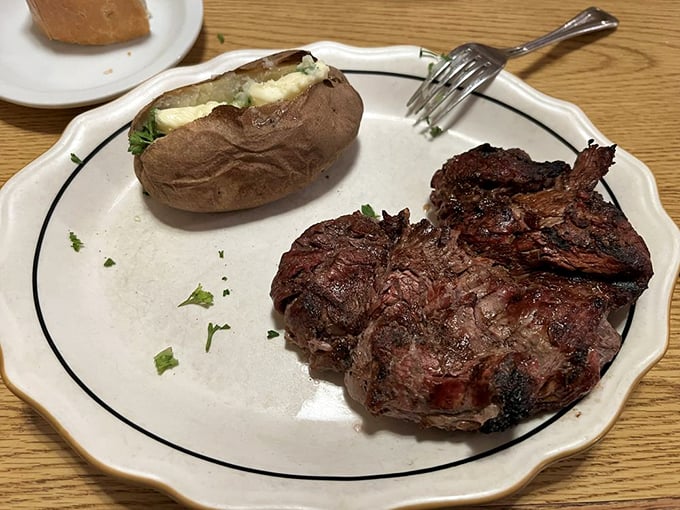 Filet mignon and a loaded baked potato—the Fred Astaire and Ginger Rogers of steakhouse pairings, dancing perfectly together on a simple white plate.