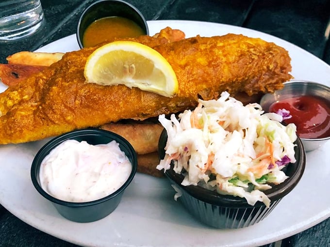 Fish and chips done right – crispy golden batter shattering at first bite to reveal flaky white fish. The coleslaw and tartar sauce are just supporting actors in this British classic.