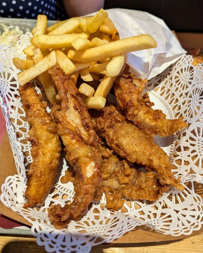 Golden fish strips that shatter like glass at first bite, paired with fries that could make a Frenchman weep with joy.