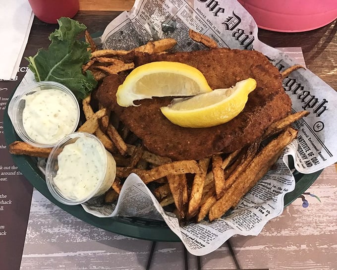 Fish and chips served on newspaper—a nod to tradition that says, "We care more about flavor than fancy presentation." Those two dipping sauces are about to become your new best friends.