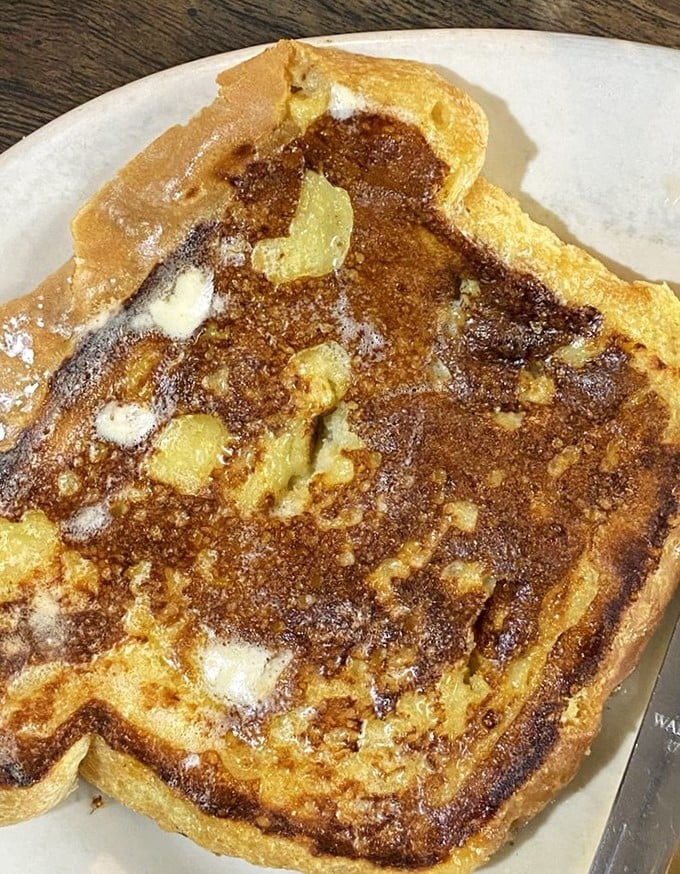 French toast that's achieved the impossible balance—crispy edges, custardy center, and enough butter to make a cardiologist wince but worth every delicious moment.