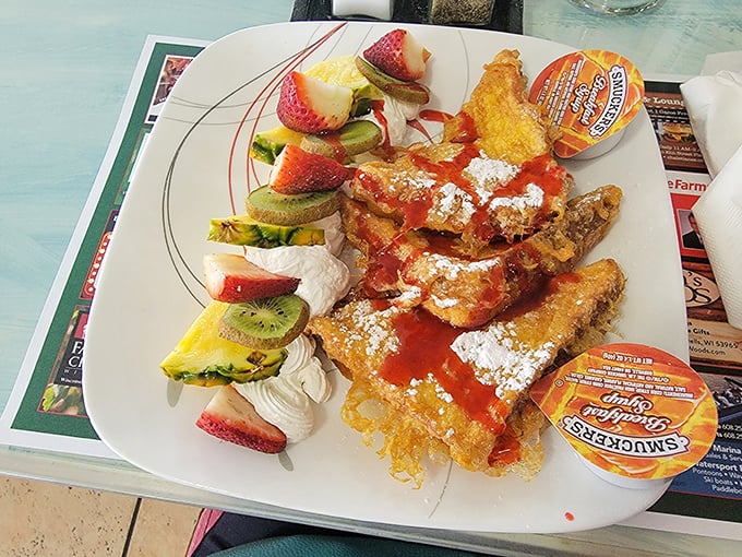 French toast that's dressed for success with fresh fruit, whipped cream, and what appears to be strawberry sauce. Breakfast or dessert? Why choose?