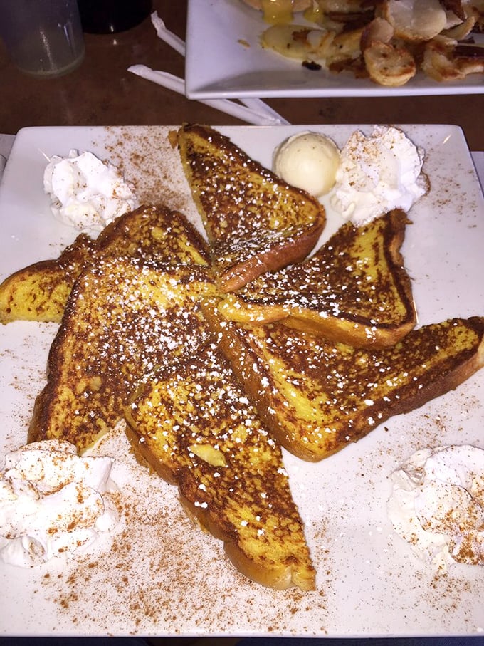 French toast that's dressed for success—golden, cinnamon-dusted, and surrounded by whipped cream islands. Breakfast or dessert? The line deliciously blurs.