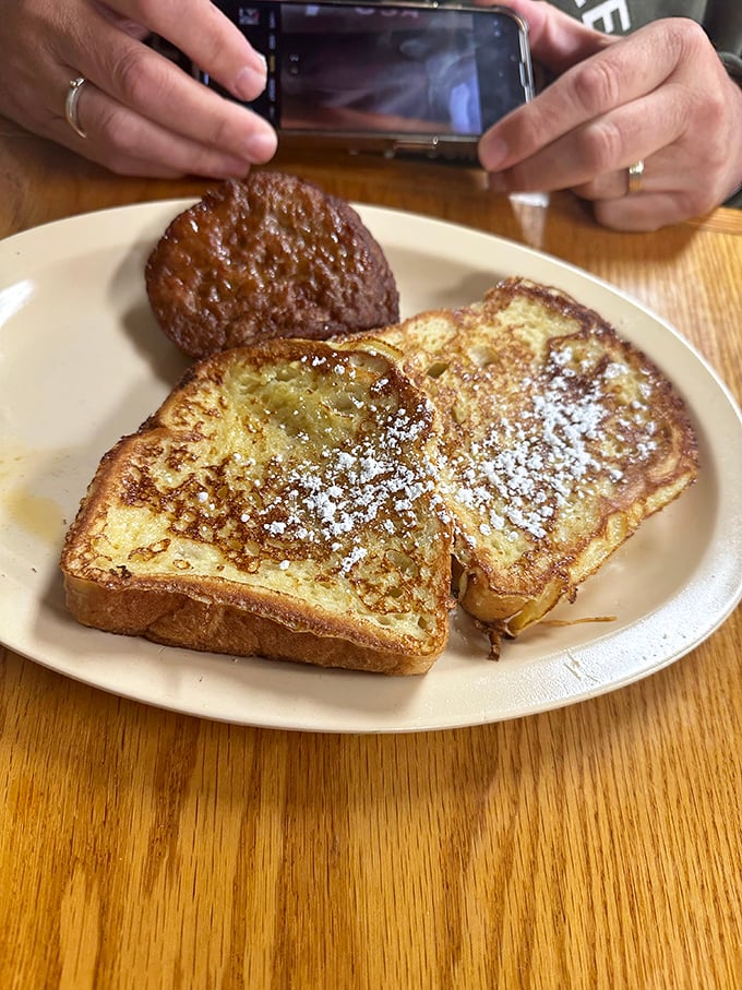 French toast dusted with powdered sugar and a side of sausage—proof that sometimes the simplest breakfast combinations are culinary poetry on a plate.