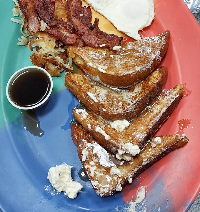French toast so perfectly golden it belongs in Fort Knox. Served on a colorful plate that's almost as cheerful as you'll be after eating it.