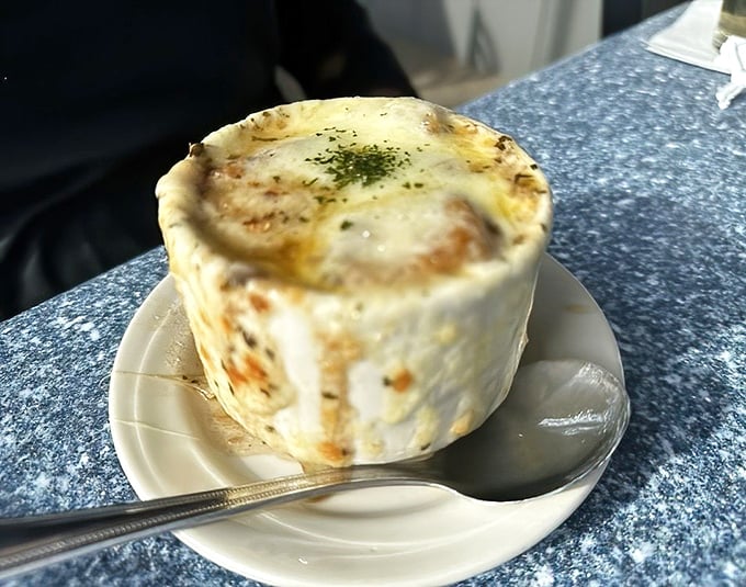 French onion soup with a crown of melted cheese that would make Louis XIV jealous – worth every moment of post-meal breath mint necessity.