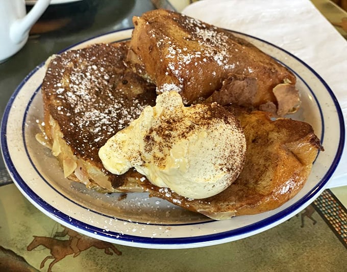 French toast that's lived its best life—thick-cut, golden-brown, and dusted with enough cinnamon and sugar to make your dentist wince approvingly.