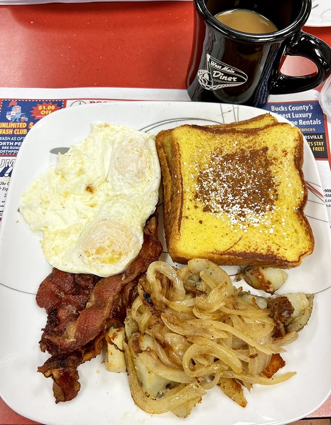 The classic breakfast trinity: eggs, bacon, and French toast dusted with powdered sugar. The holy grail of morning meals.