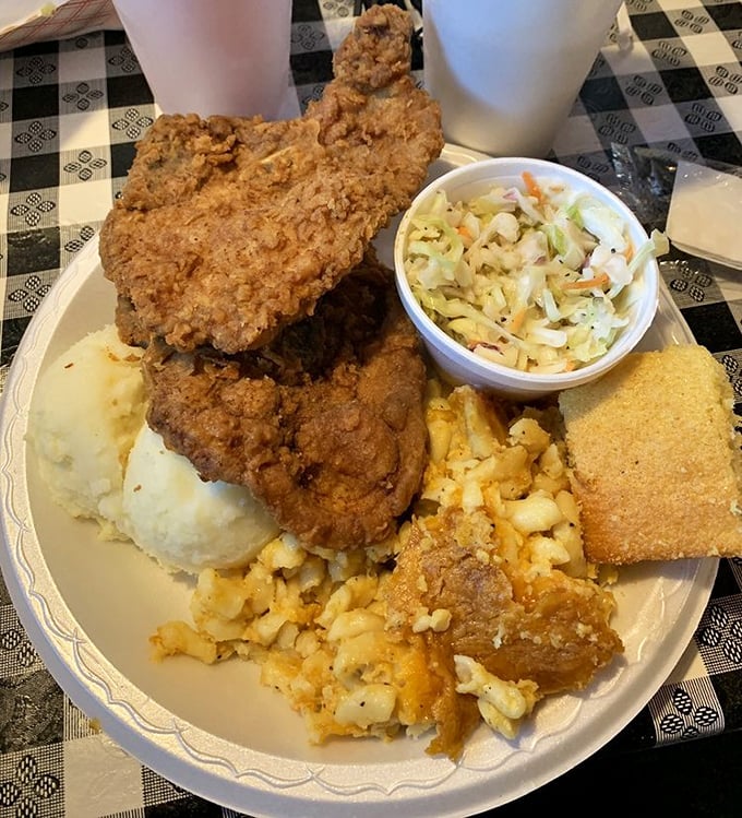 A plate that means business: fried chicken, mashed potatoes, mac and cheese, coleslaw, and cornbread – the kind of meal that demands a post-dinner nap.