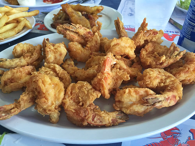 Golden-battered shrimp piled high like delicious treasure. Each one perfectly fried—crispy outside, succulent inside—ready to be devoured by the plateful.