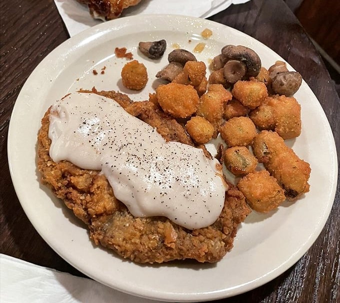 Country-fried steak smothered in gravy with a side of fried okra—a plate that says "you're definitely in the Ozarks now, friend."