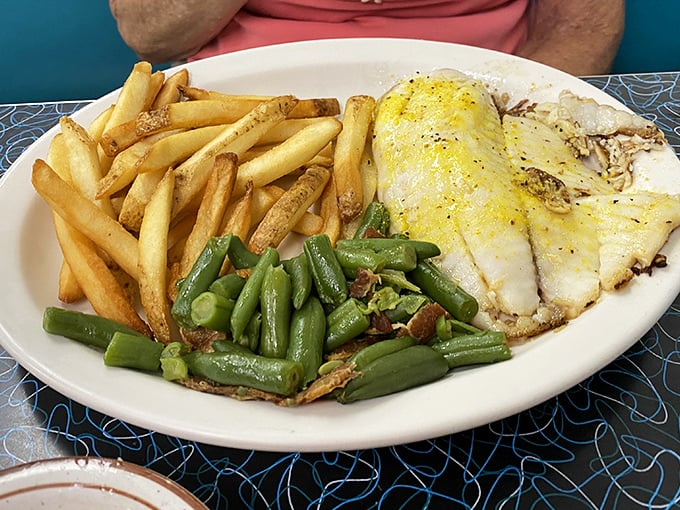 Simple pleasures done right: perfectly fried tilapia with crispy fries and green beans. No foam, no "deconstructed" nonsense—just food that makes you happy.
