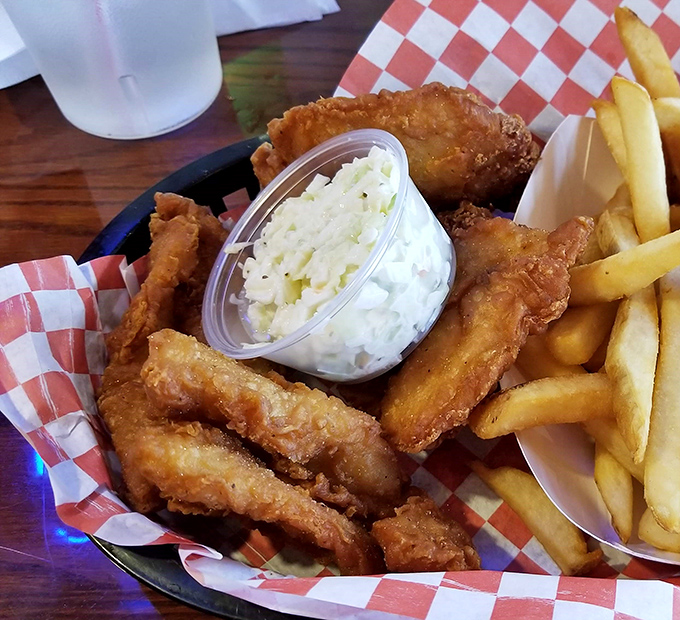 A basket of crispy delights paired with fresh-cut fries and homemade coleslaw—the holy trinity of fish house perfection that keeps locals coming back weekly.
