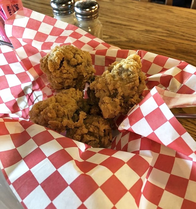 Fried mushrooms nestled in their red-checkered paper throne—golden, crispy armor protecting tender treasures within. Worth every napkin.