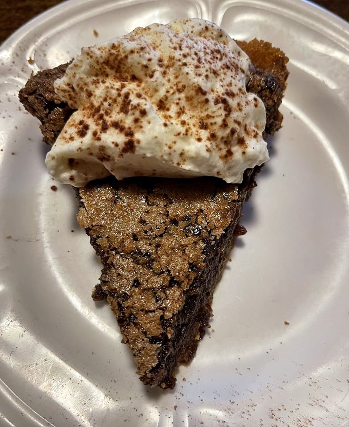 A slice of fudge pie topped with cream that doesn't just satisfy your sweet tooth – it throws a party for it and invites all its friends.
