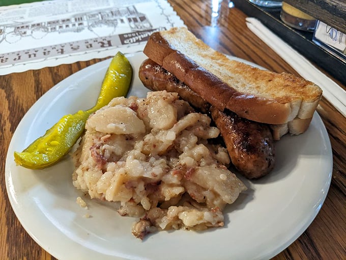 A sausage lounging on a bed of sauerkraut with potato salad and pretzel bread—it's like a spa retreat for your taste buds. 