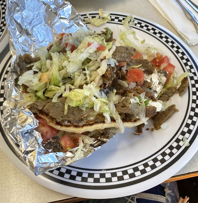 The gyro plate arrives like a deconstructed masterpiece—seasoned meat, fresh vegetables, and warm pita creating the holy trinity of Greek street food.