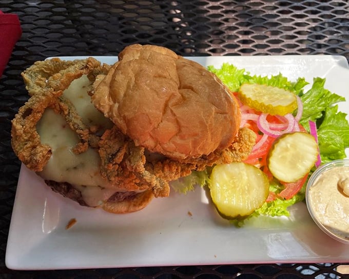 This burger doesn't just come with cheese – it surrenders to it completely, with a golden blanket that's worth every napkin you'll need.