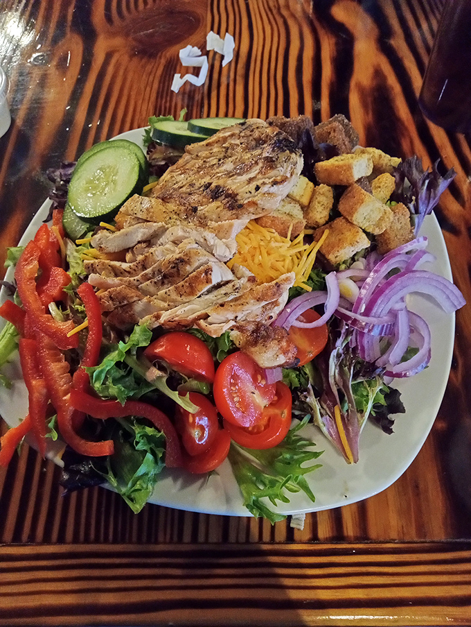 A vibrant salad that proves healthy eating doesn't mean punishment – grilled chicken and fresh vegetables creating a colorful canvas of flavors.