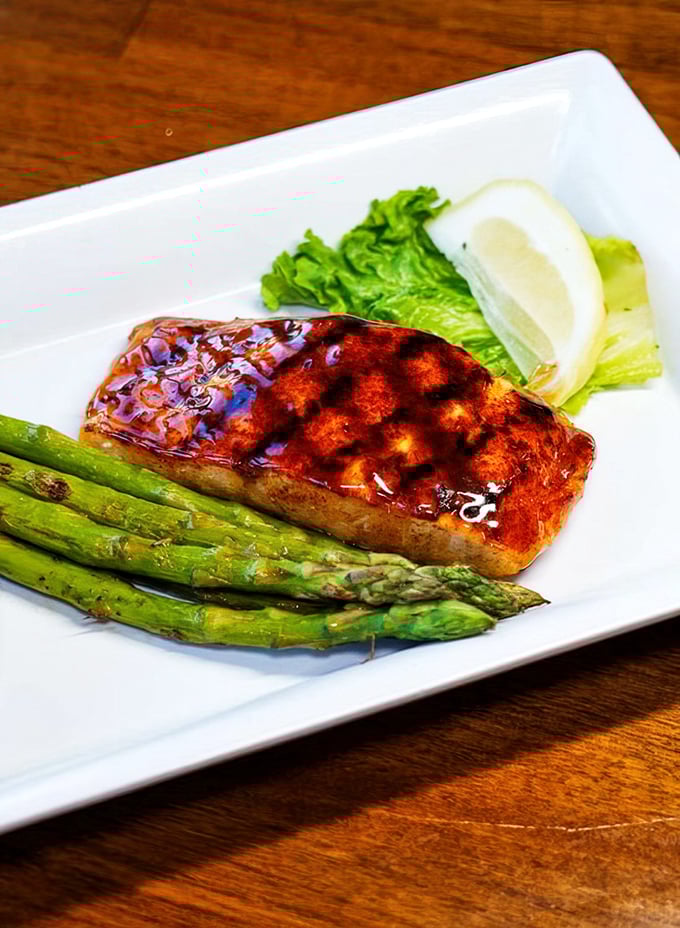 This glazed salmon with asparagus isn't just dinner—it's edible artwork. The caramelized exterior glistens with a promise it absolutely keeps.